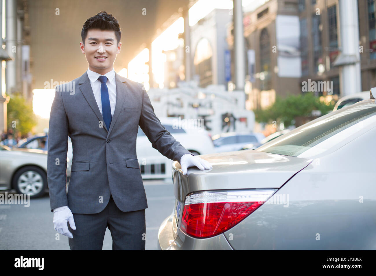 Portrait of chauffeur standing next to the car Stock Photo - Alamy