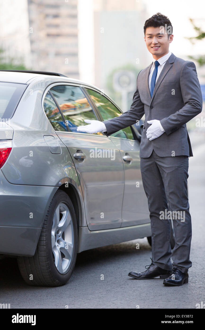 Portrait of chauffeur standing next to the car Stock Photo - Alamy