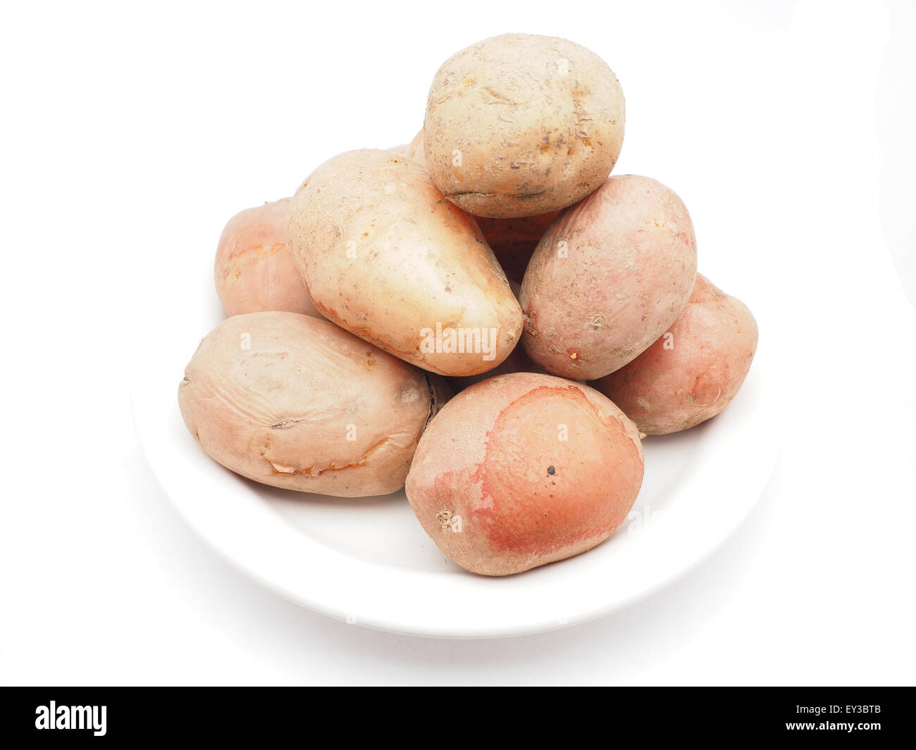 unpeeled potatoes on a white background Stock Photo - Alamy