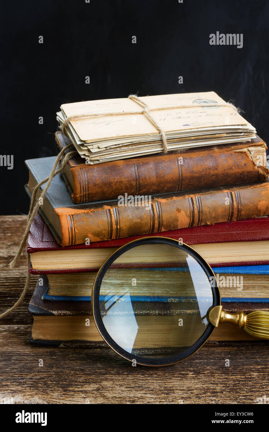 pile of books with looking glass Stock Photo - Alamy