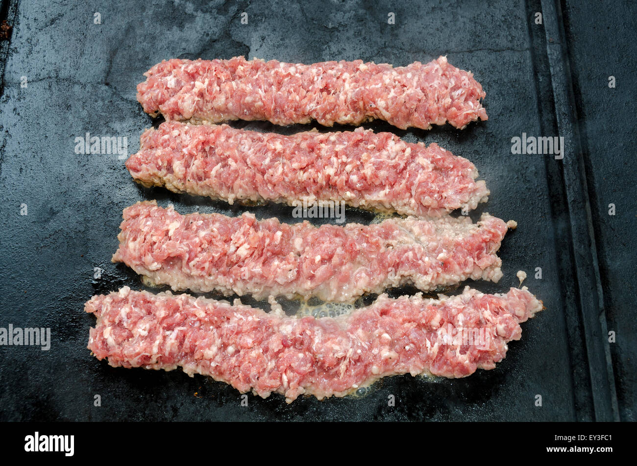 uncooked sausage while cooking on the grill Stock Photo - Alamy