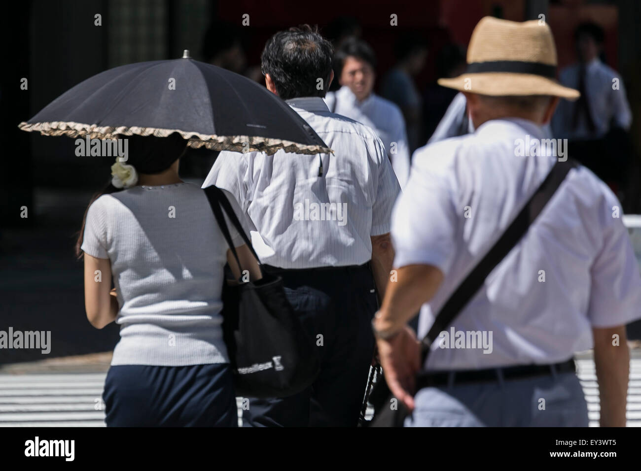 Tokyo, Japan. 21st July, 2015. Japanese office workers walk under the ...