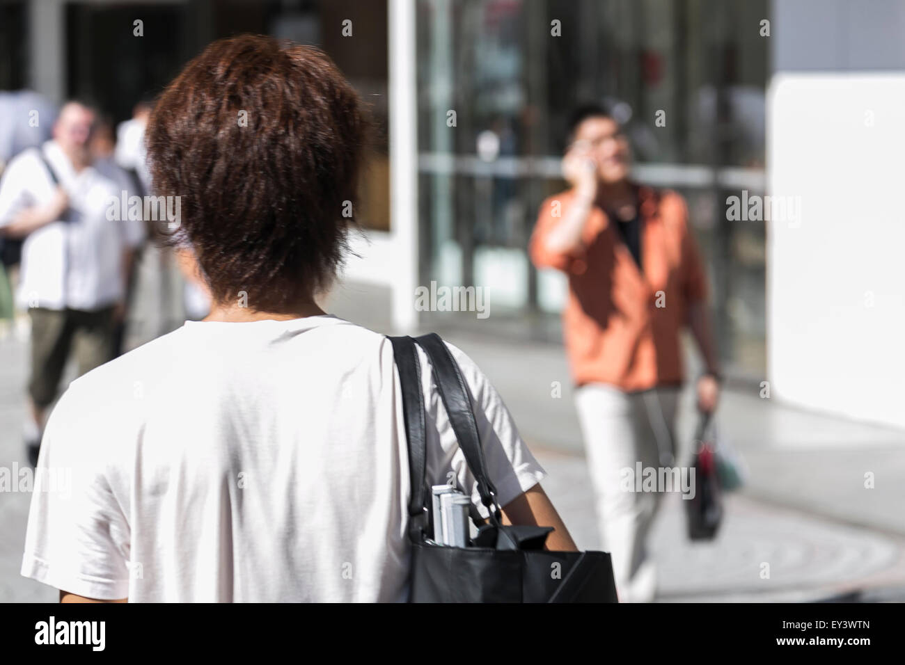 Tokyo, Japan. 21st July, 2015. Japanese office workers walk under the ...