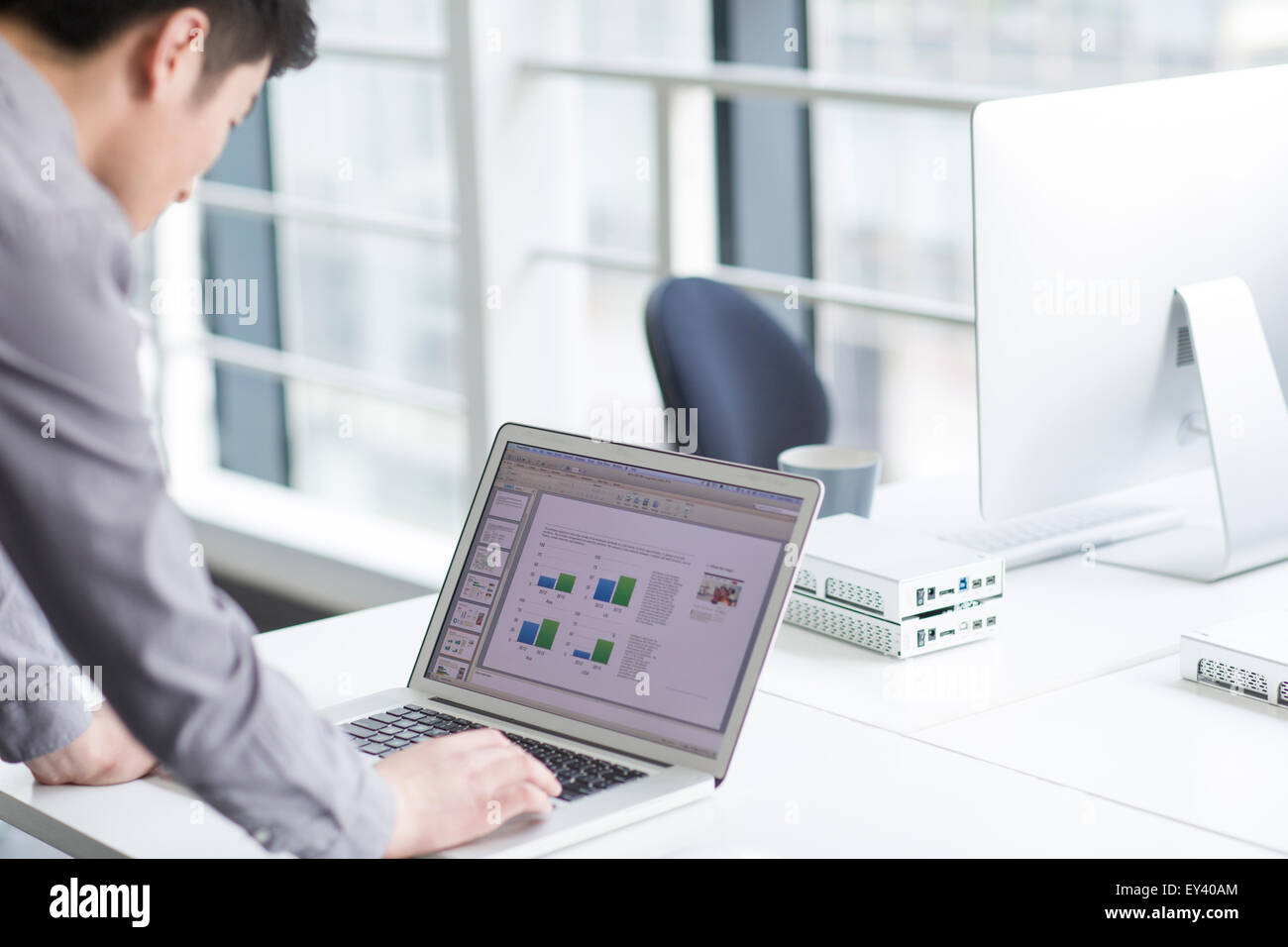 Young businessman using laptop in office Stock Photo - Alamy