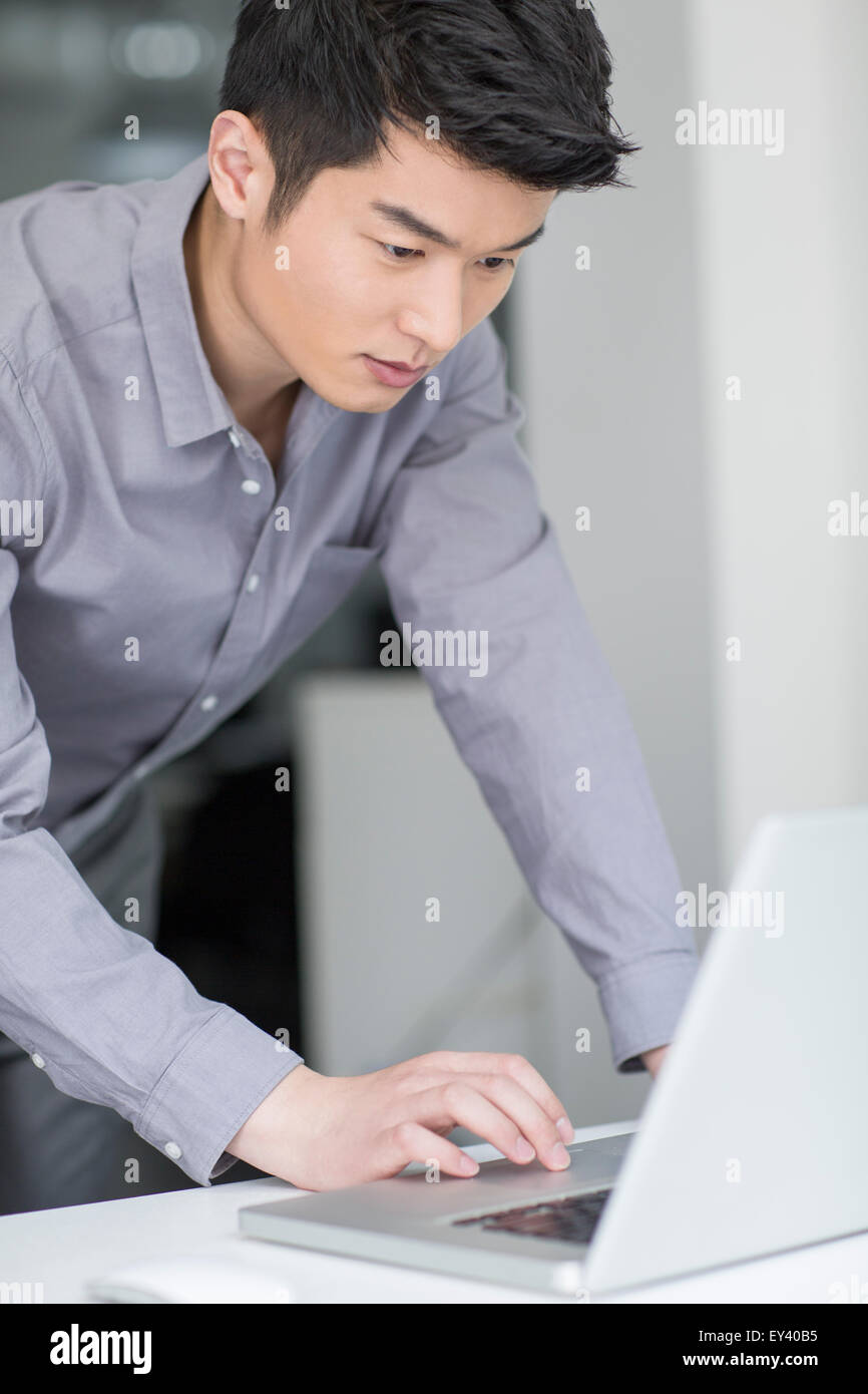 Young businessman using laptop in office Stock Photo - Alamy