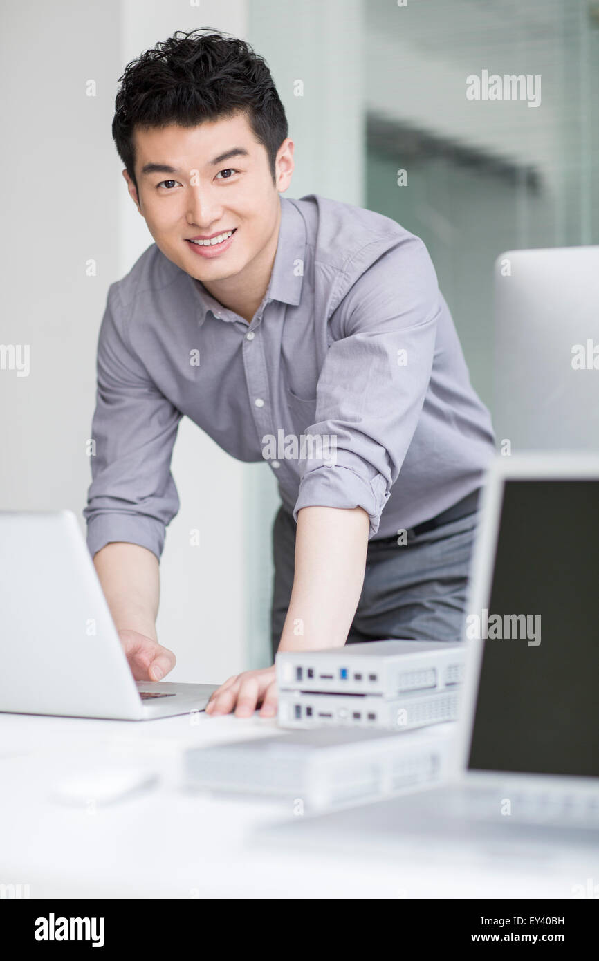 Young businessman using laptop in office Stock Photo - Alamy
