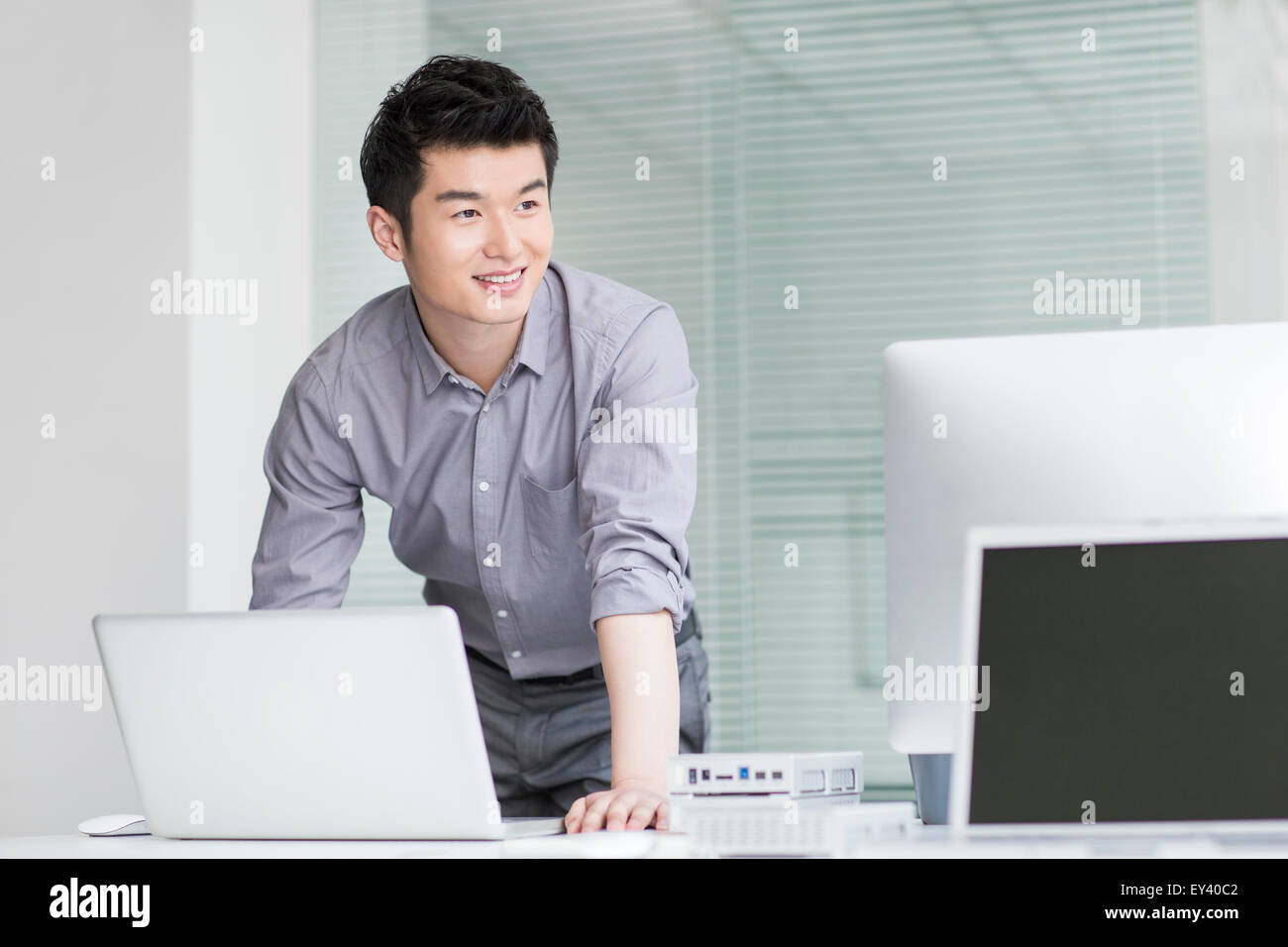 Young businessman using laptop in office Stock Photo - Alamy