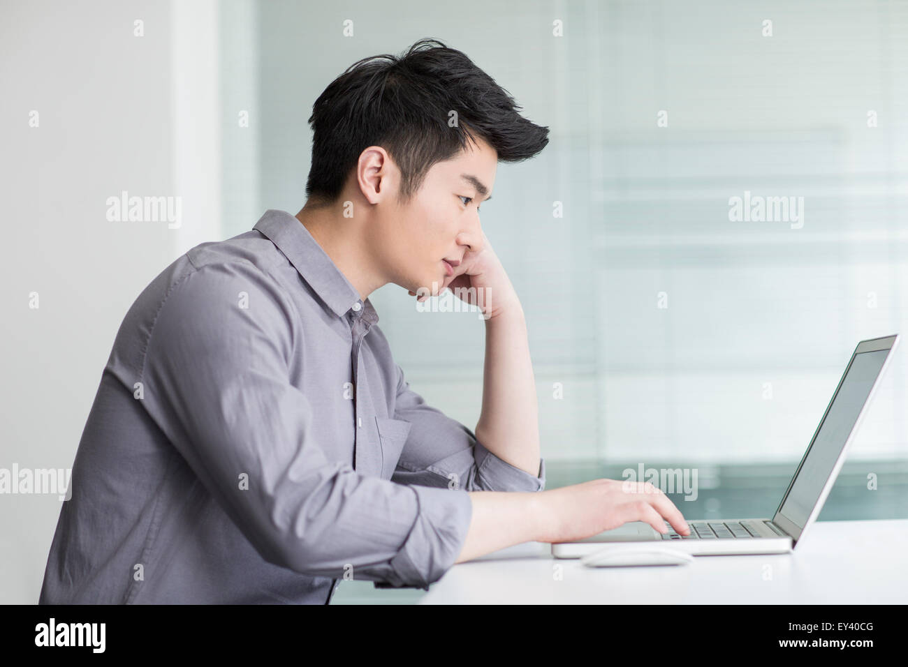 Young businessman using laptop in office Stock Photo - Alamy