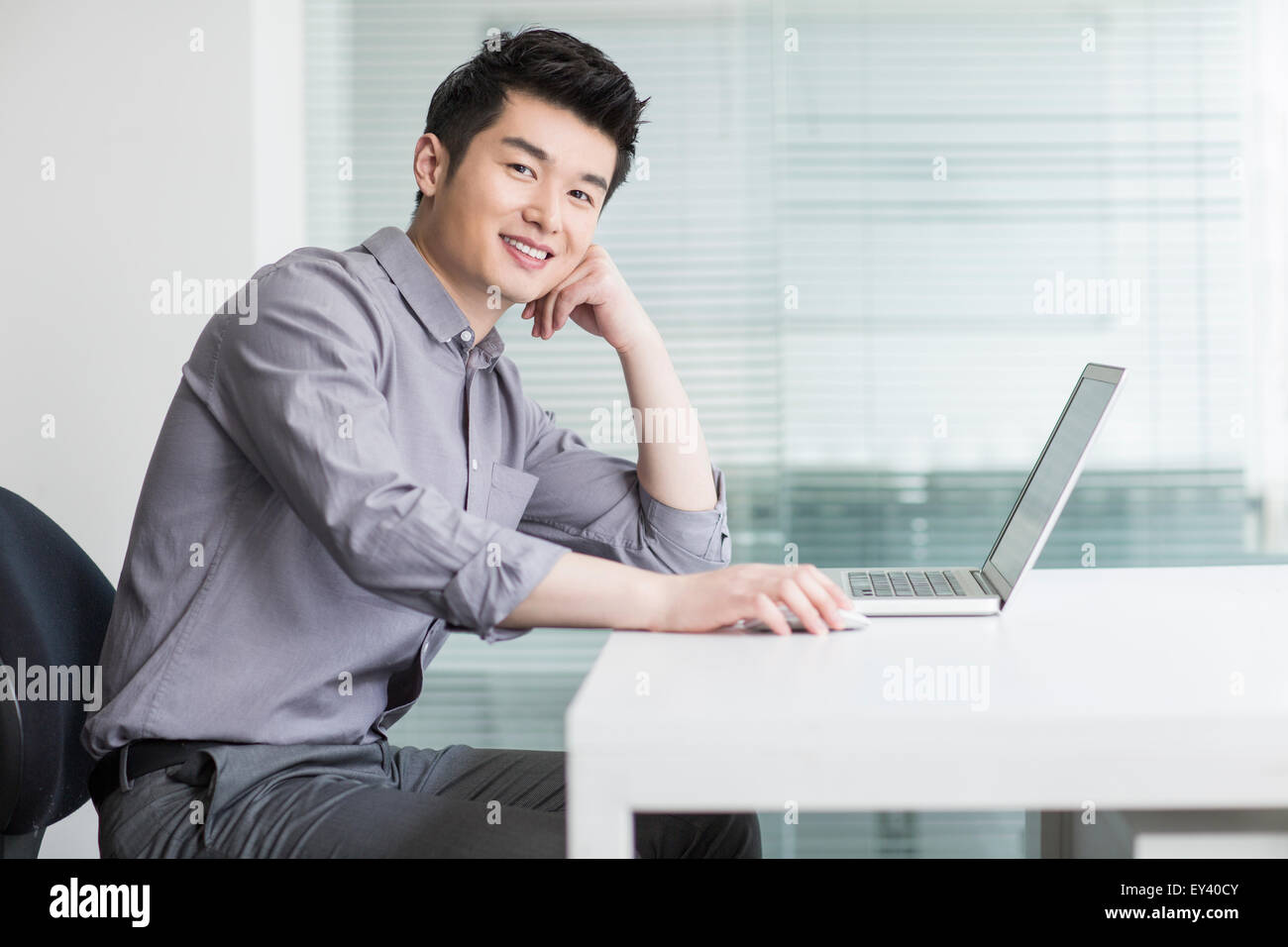 Young businessman using laptop in office Stock Photo - Alamy