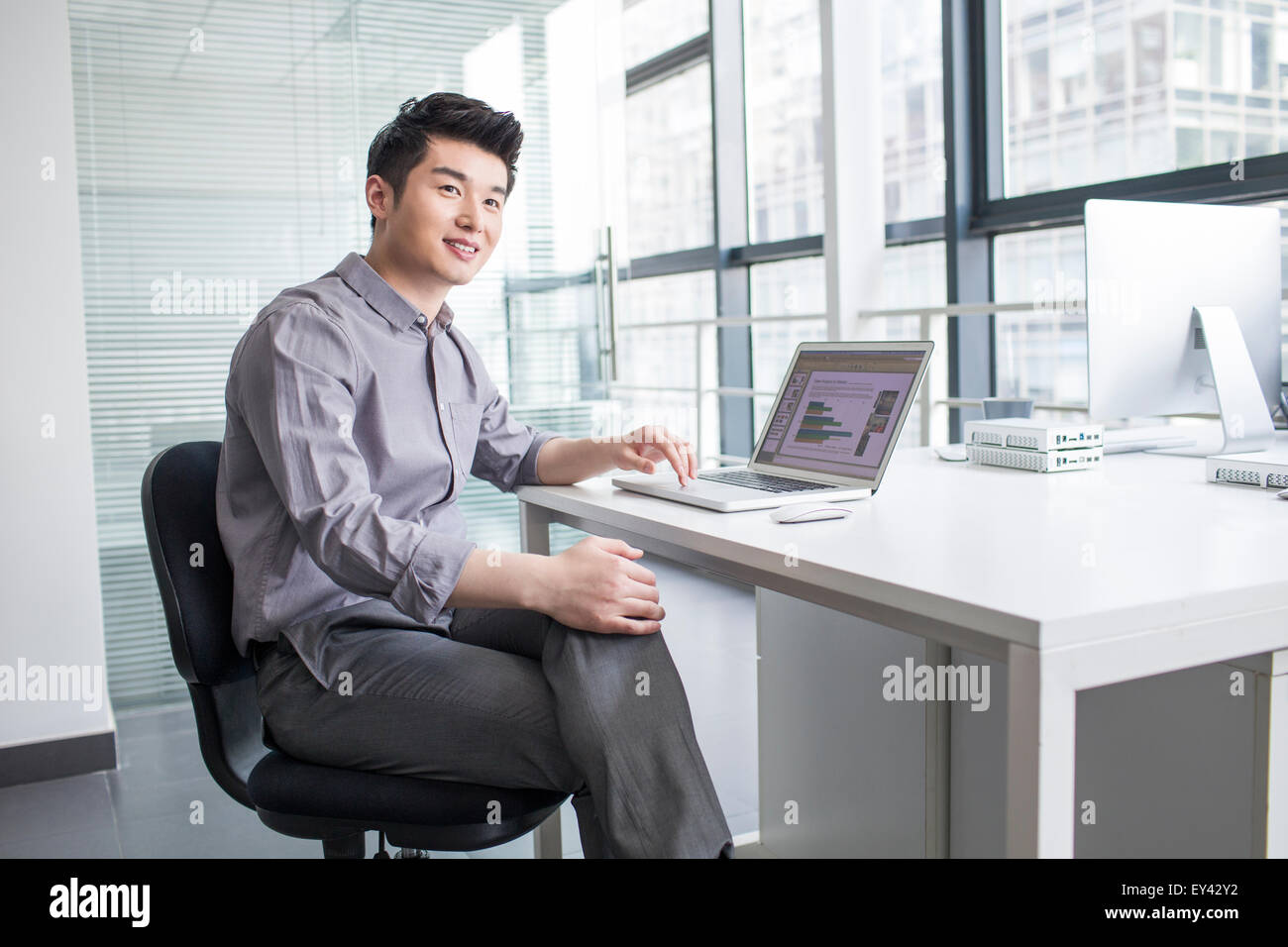 Young businessman using laptop in office Stock Photo - Alamy