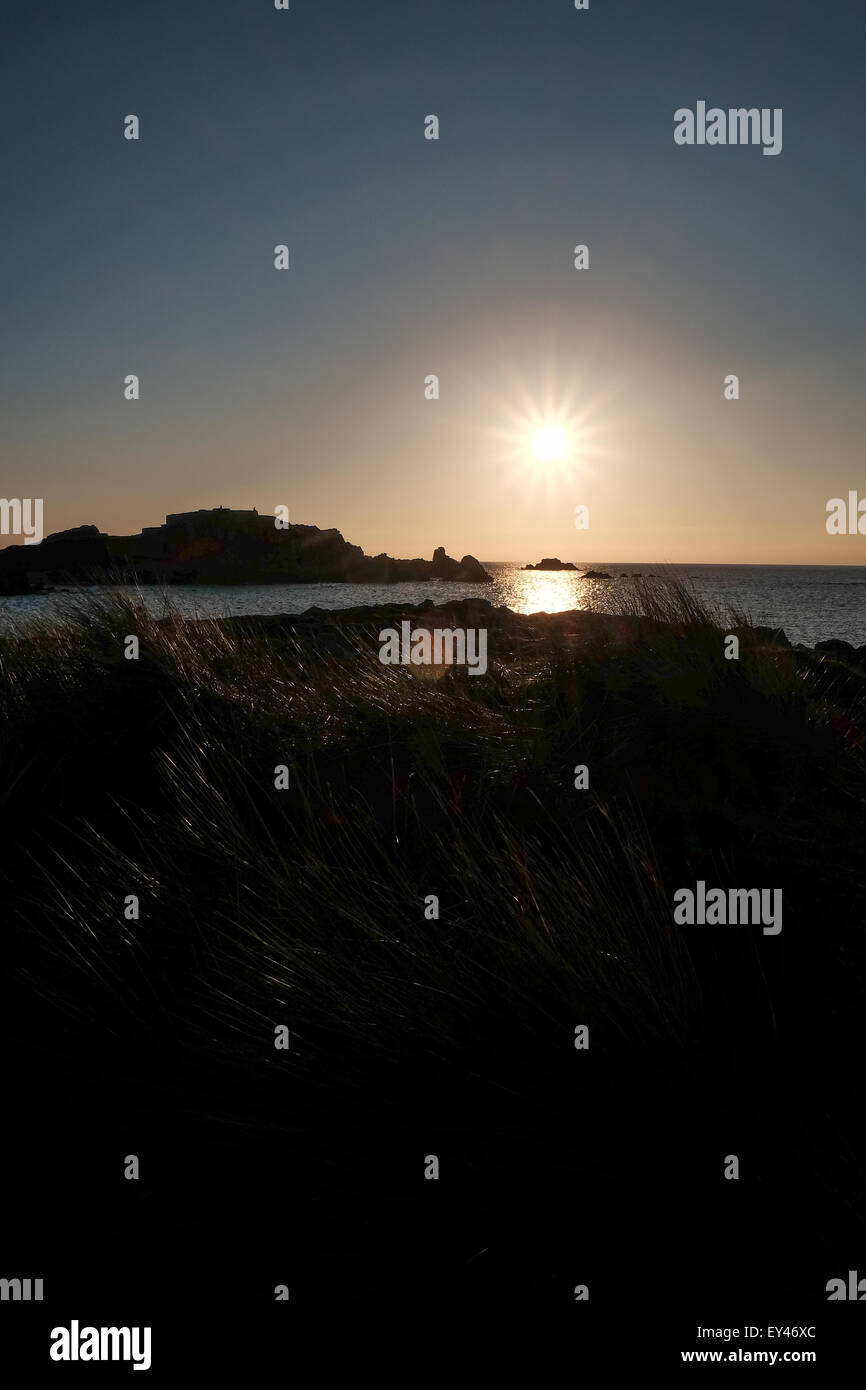 Sunset over Guernsey beach Stock Photo - Alamy