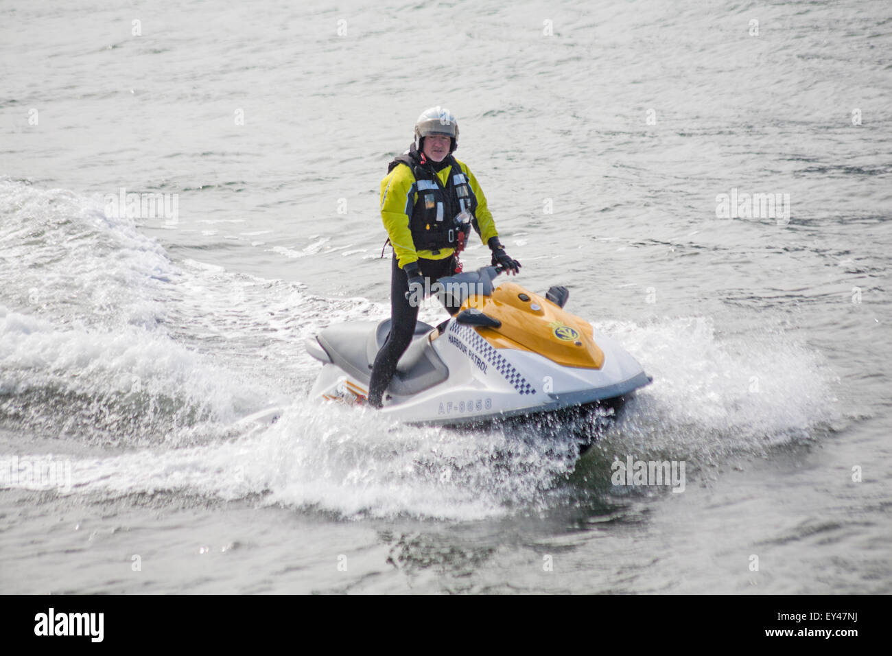 Harbour patrol man on jetski at Poole Harbour in July Stock Photo - Alamy