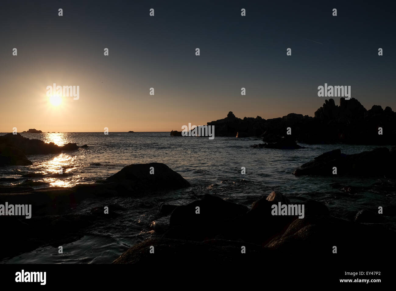 Sunset over Guernsey beach Stock Photo - Alamy
