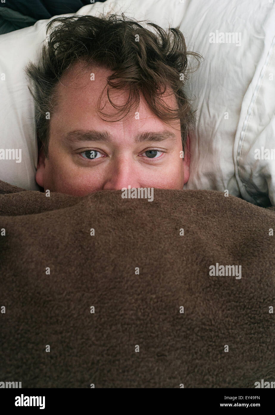 A sleepy man looking at the camera Stock Photo - Alamy