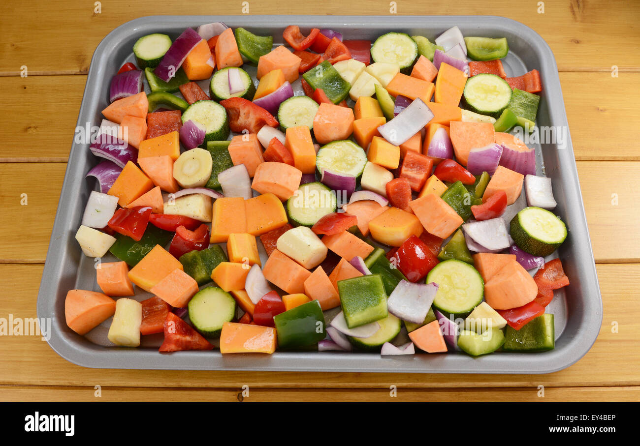 Chopped raw vegetables seasoned and drizzled with oil in preparation ...