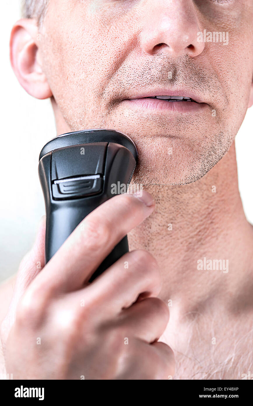 Man Shaving Face with Electric Razor Against White Background Stock ...