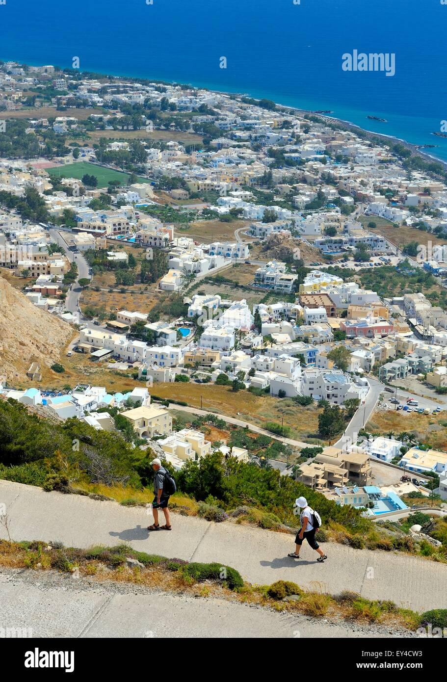 People walking up the road to Ancient Thira with Kamari in the distance ...
