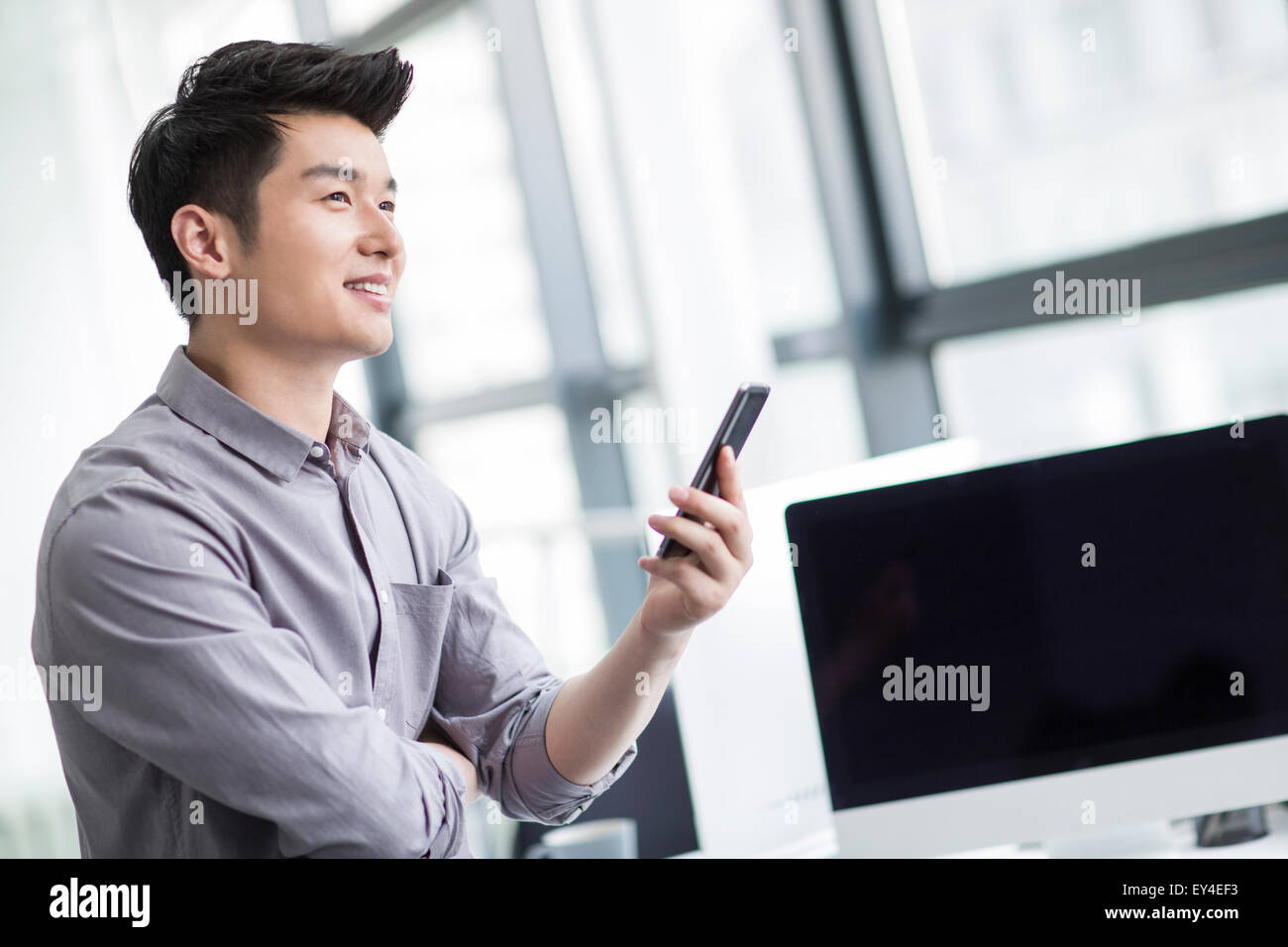 Young businessman using smart phone in office Stock Photo - Alamy