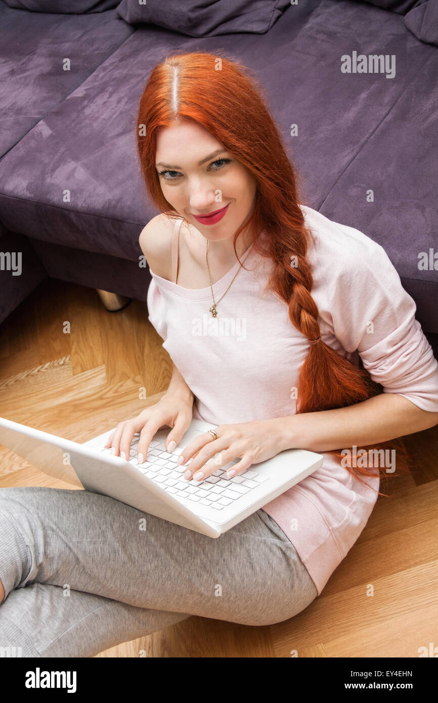 Pretty Young Woman Using her Laptop Computer In the Living Room with ...