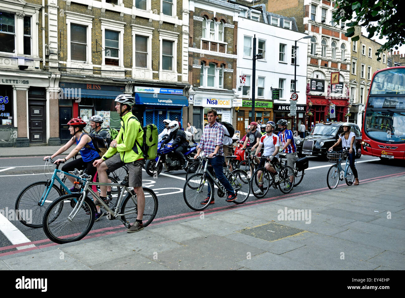 Commuter cyclists in advanced stop lane with bus behind, London Borough ...