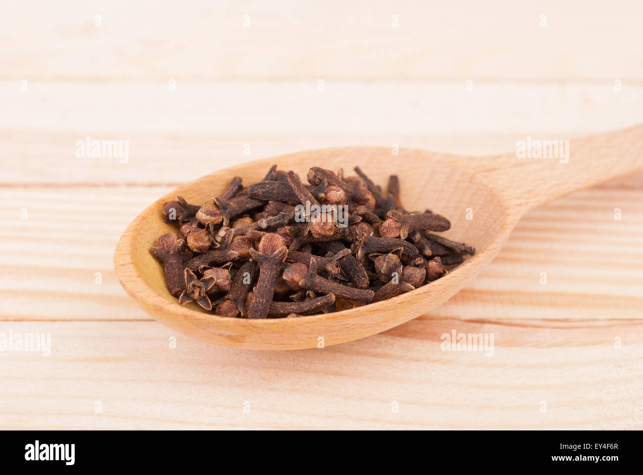 Cloves in spoon close up on a wooden table Stock Photo - Alamy