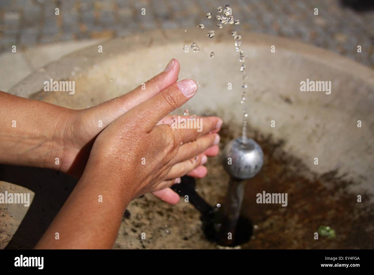 Woman's hands with cold water splash Stock Photo - Alamy