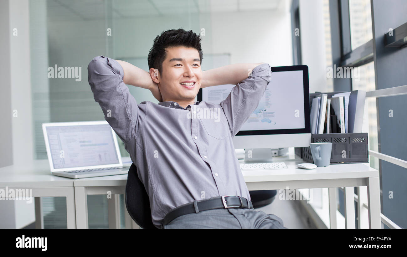 Young businessman looking through window in office Stock Photo - Alamy