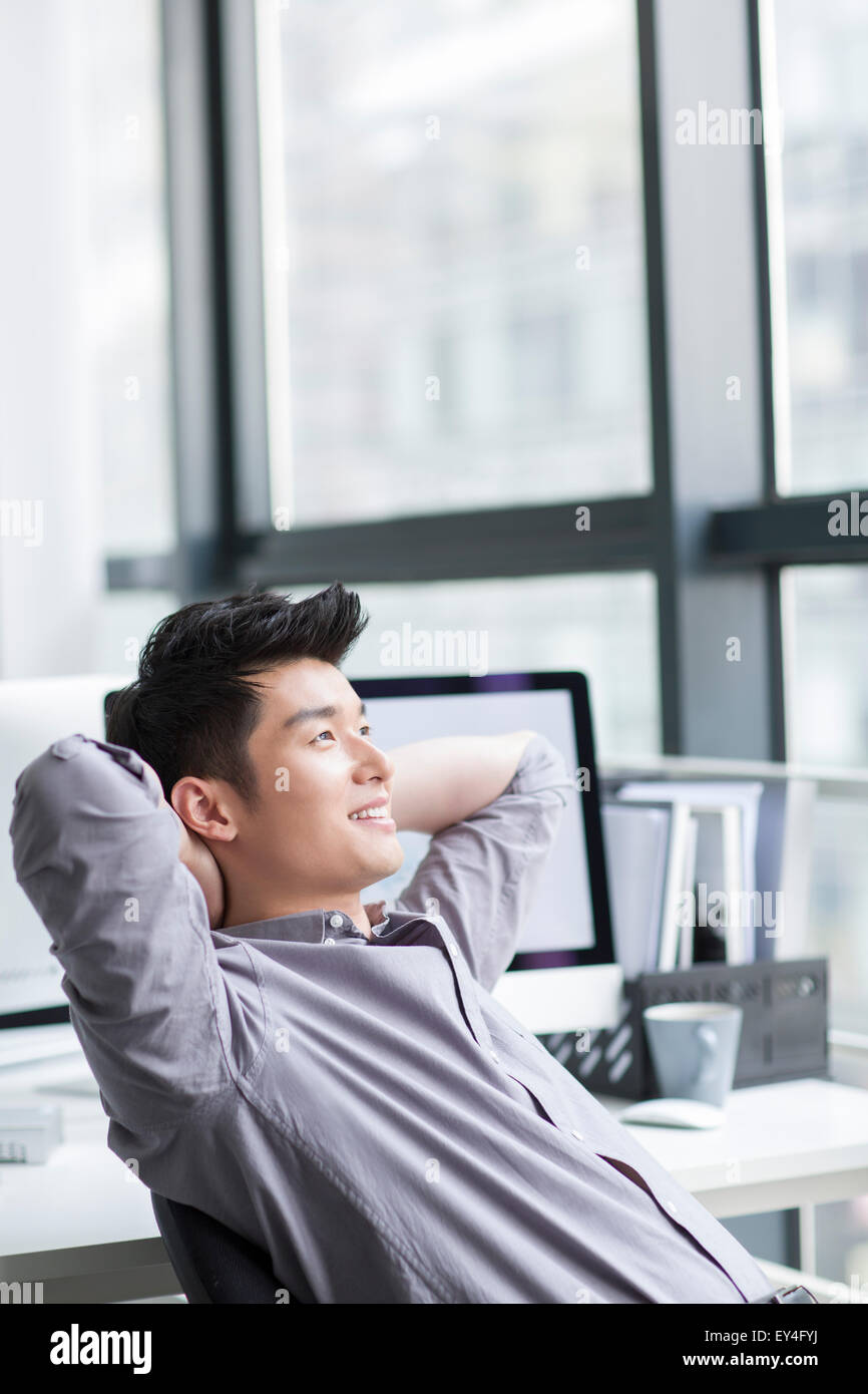 Young businessman looking through window in office Stock Photo - Alamy