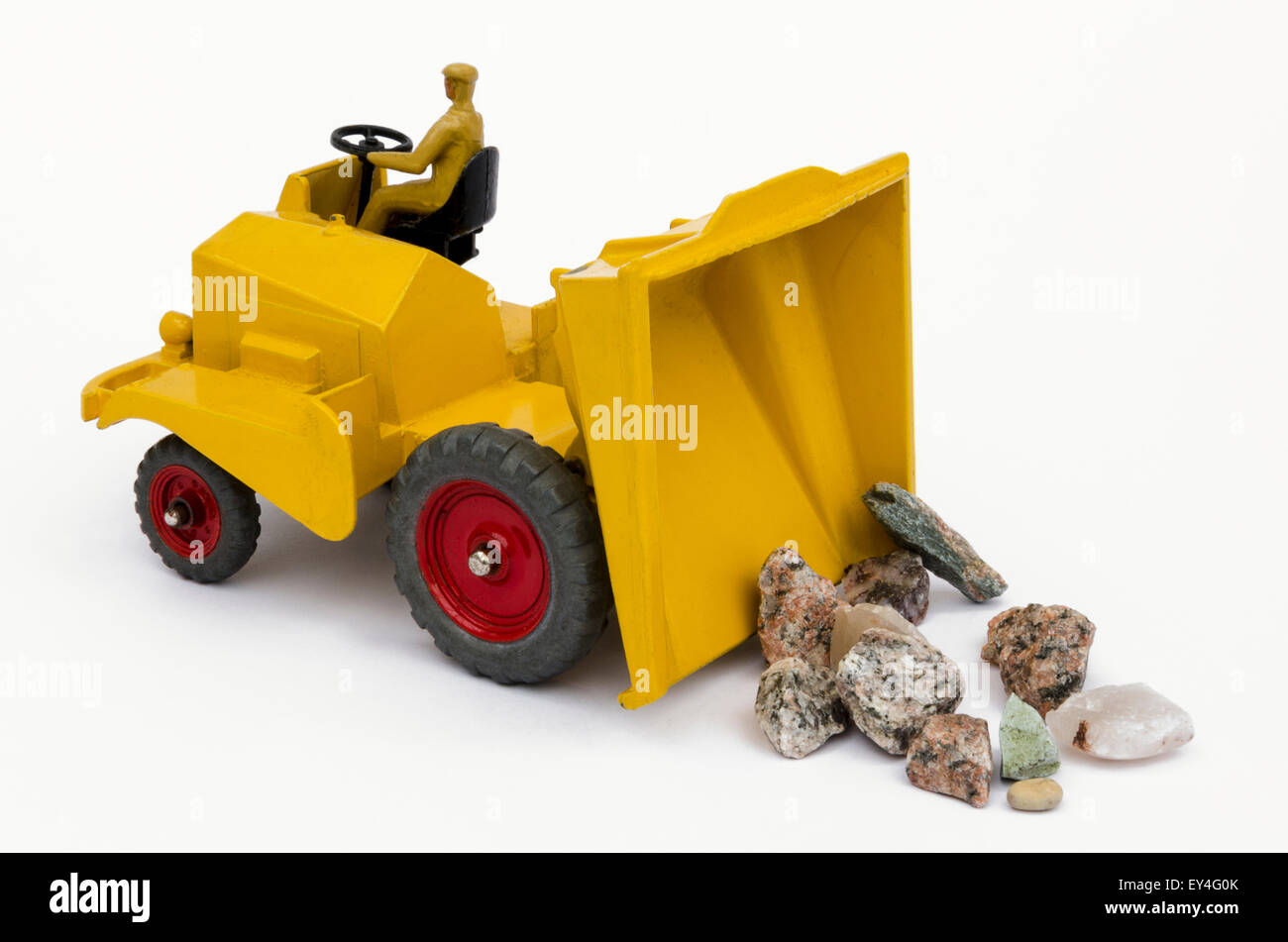 Vintage toy tipper truck tipping stones from bucket. Isolated on a ...