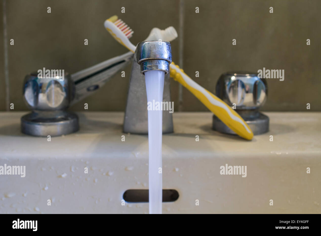 Sink with water, toothbrush and toothpaste in a bathroom Stock Photo ...