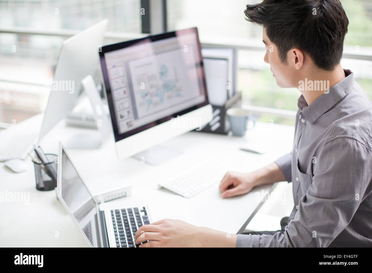 Young businessman using laptop in office Stock Photo - Alamy