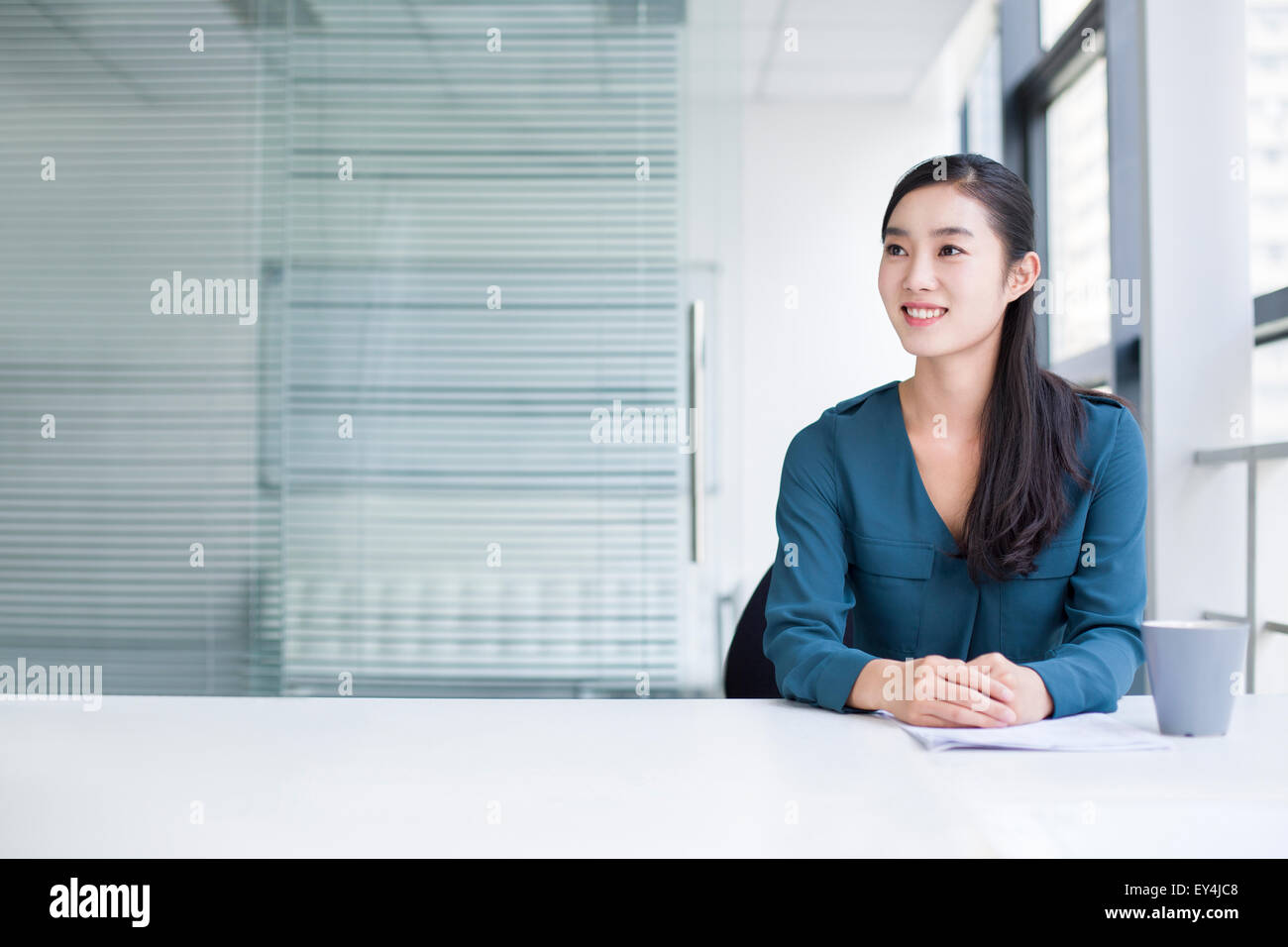 Young businesswoman thinking in office Stock Photo - Alamy
