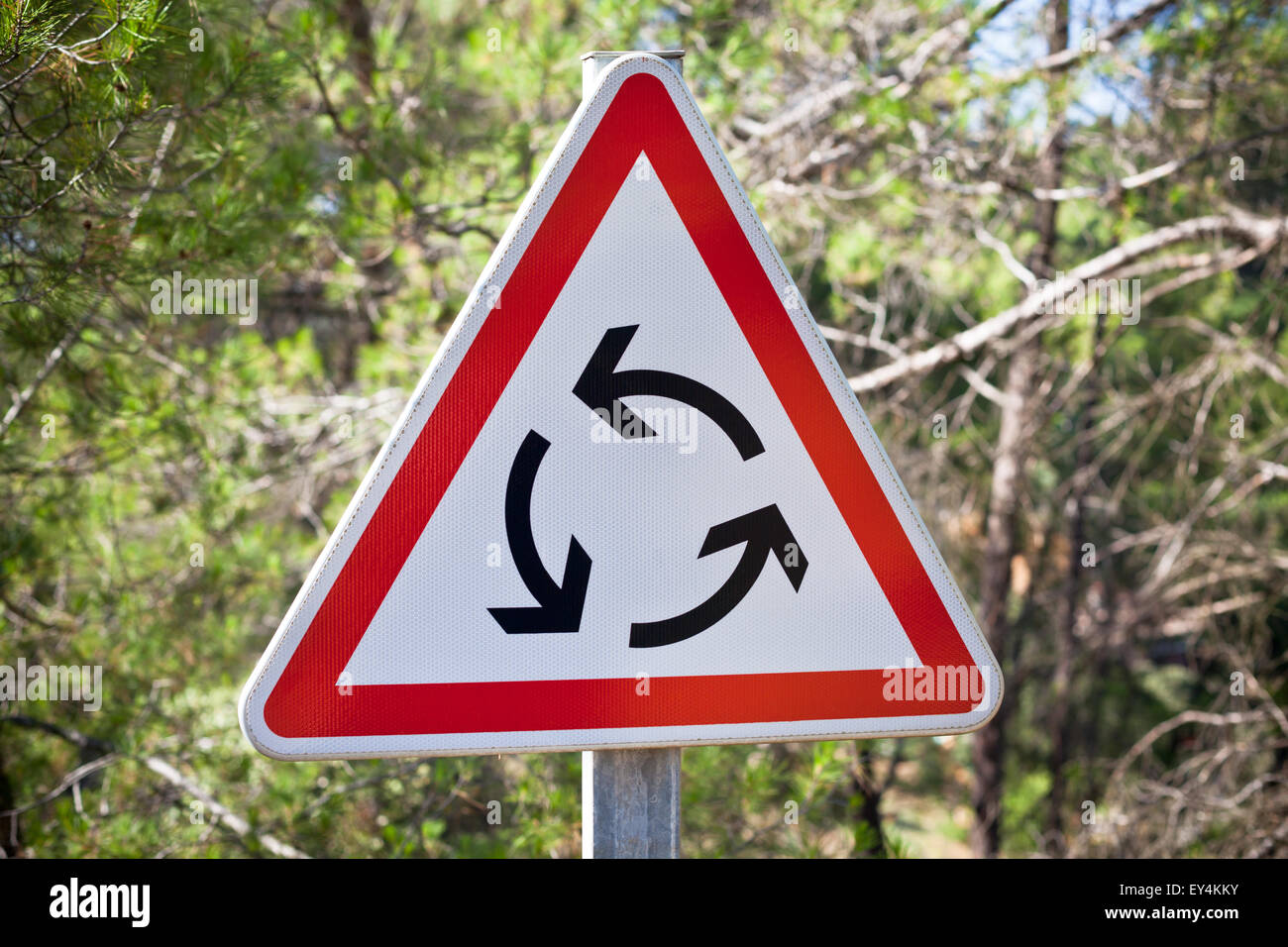 Roundabout triangle traffic sign on nature background Stock Photo - Alamy