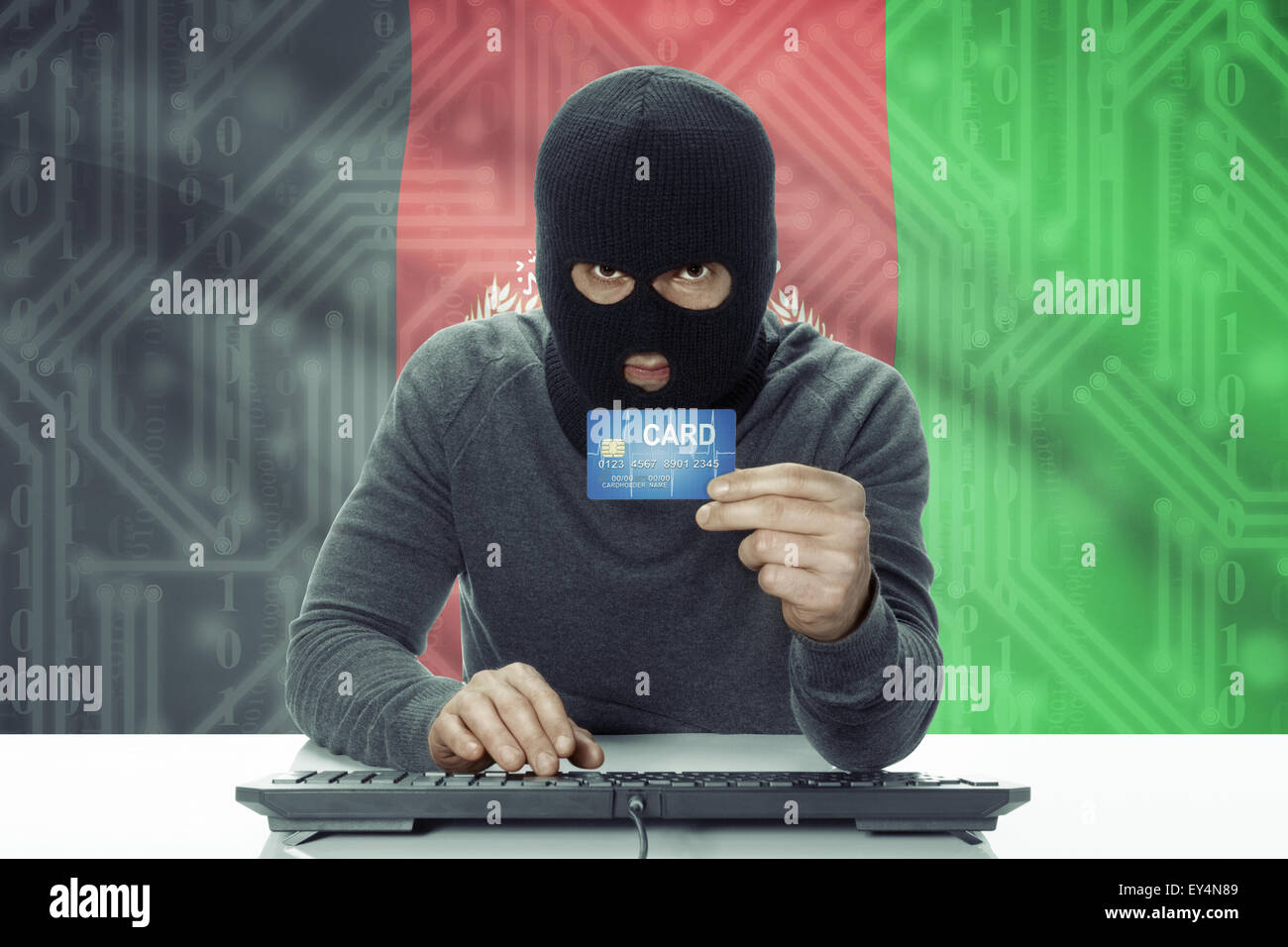 Dark-skinned hacker with credit card and flag on background ...
