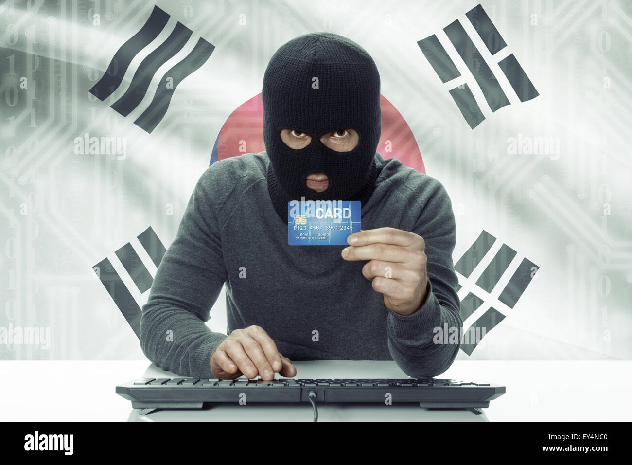 Dark-skinned hacker with credit card and flag on background - South ...