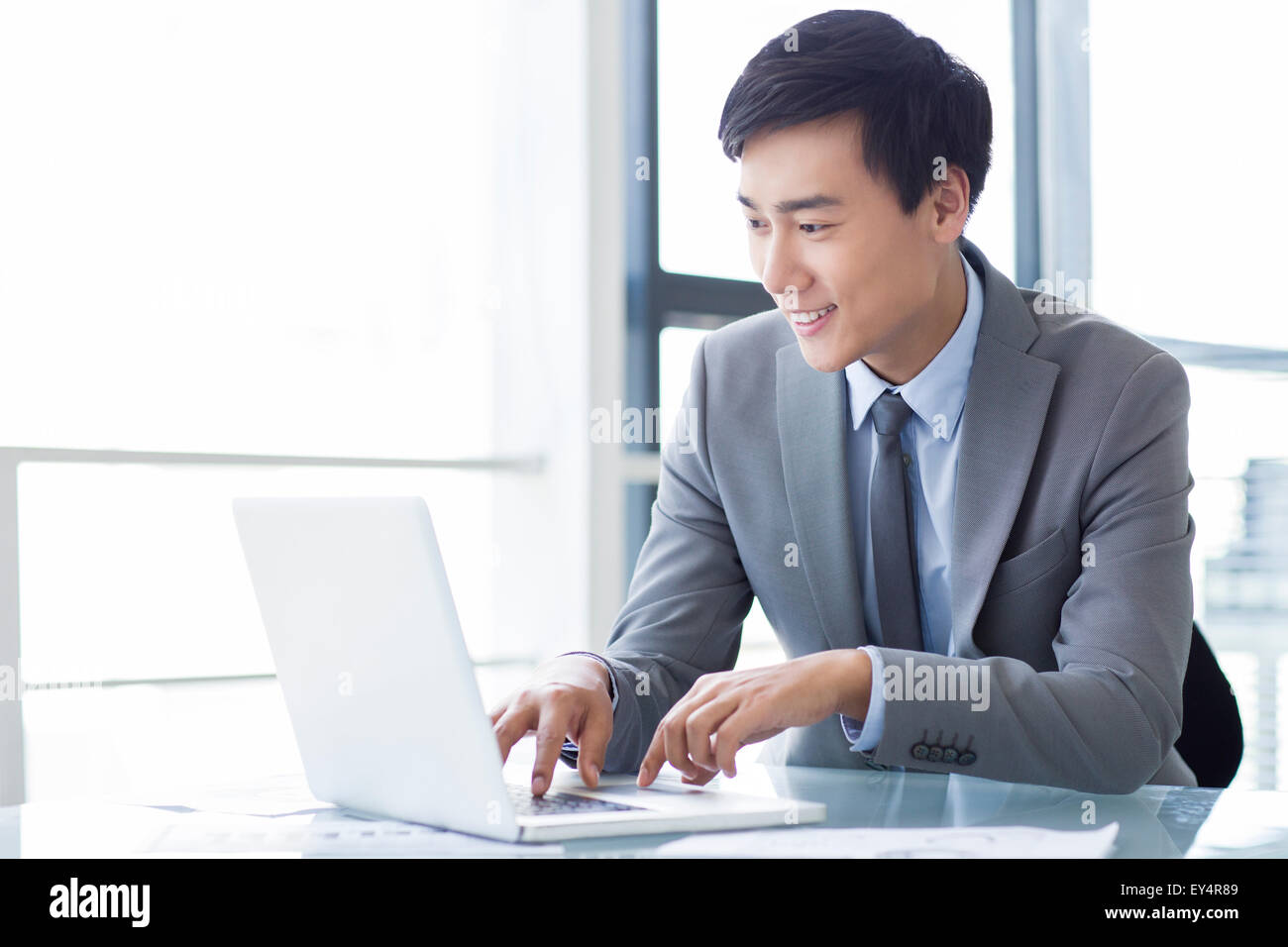 Young businessman using laptop in office Stock Photo - Alamy