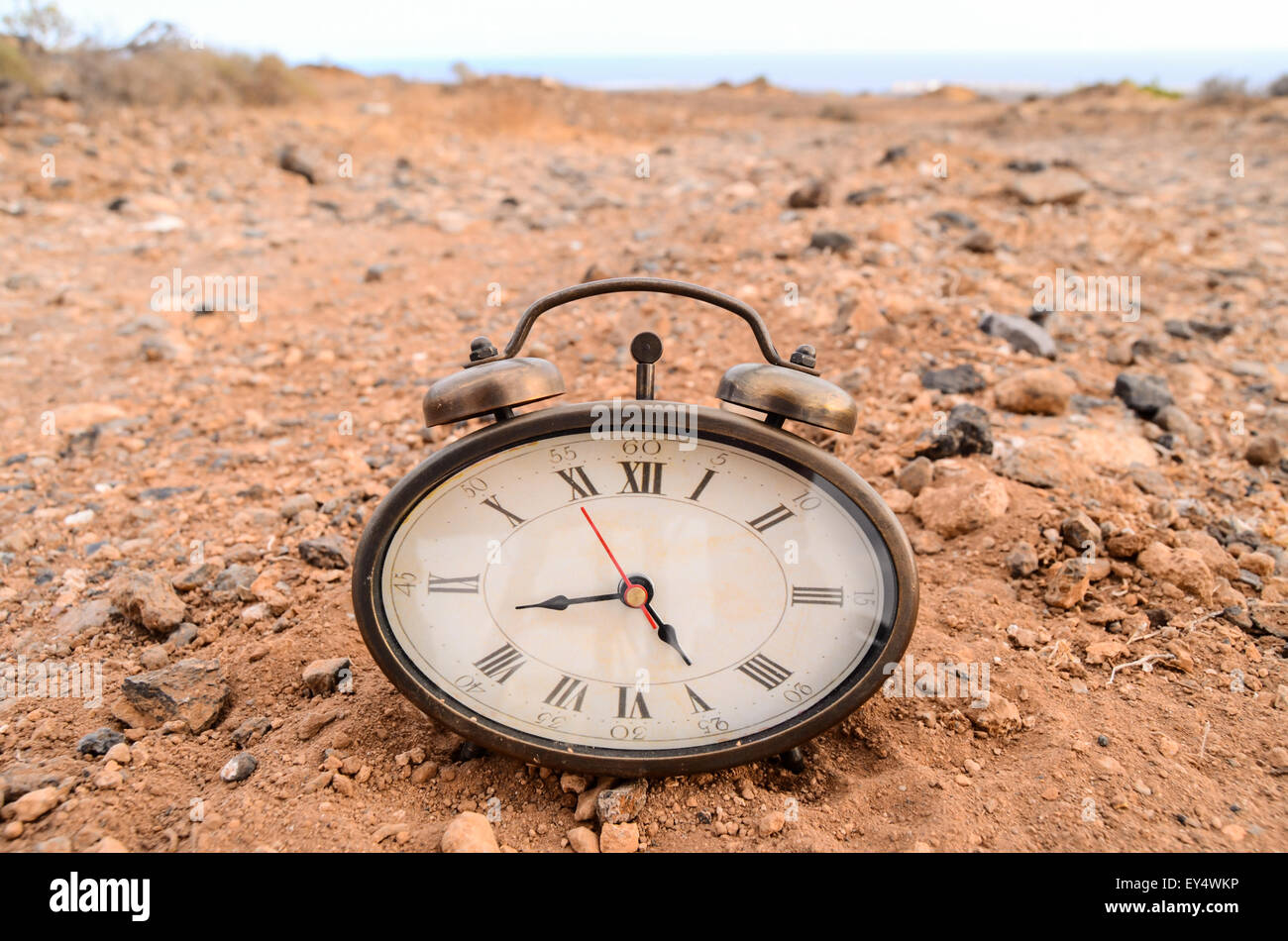 Classic Analog Clock In The Sand Stock Photo - Alamy