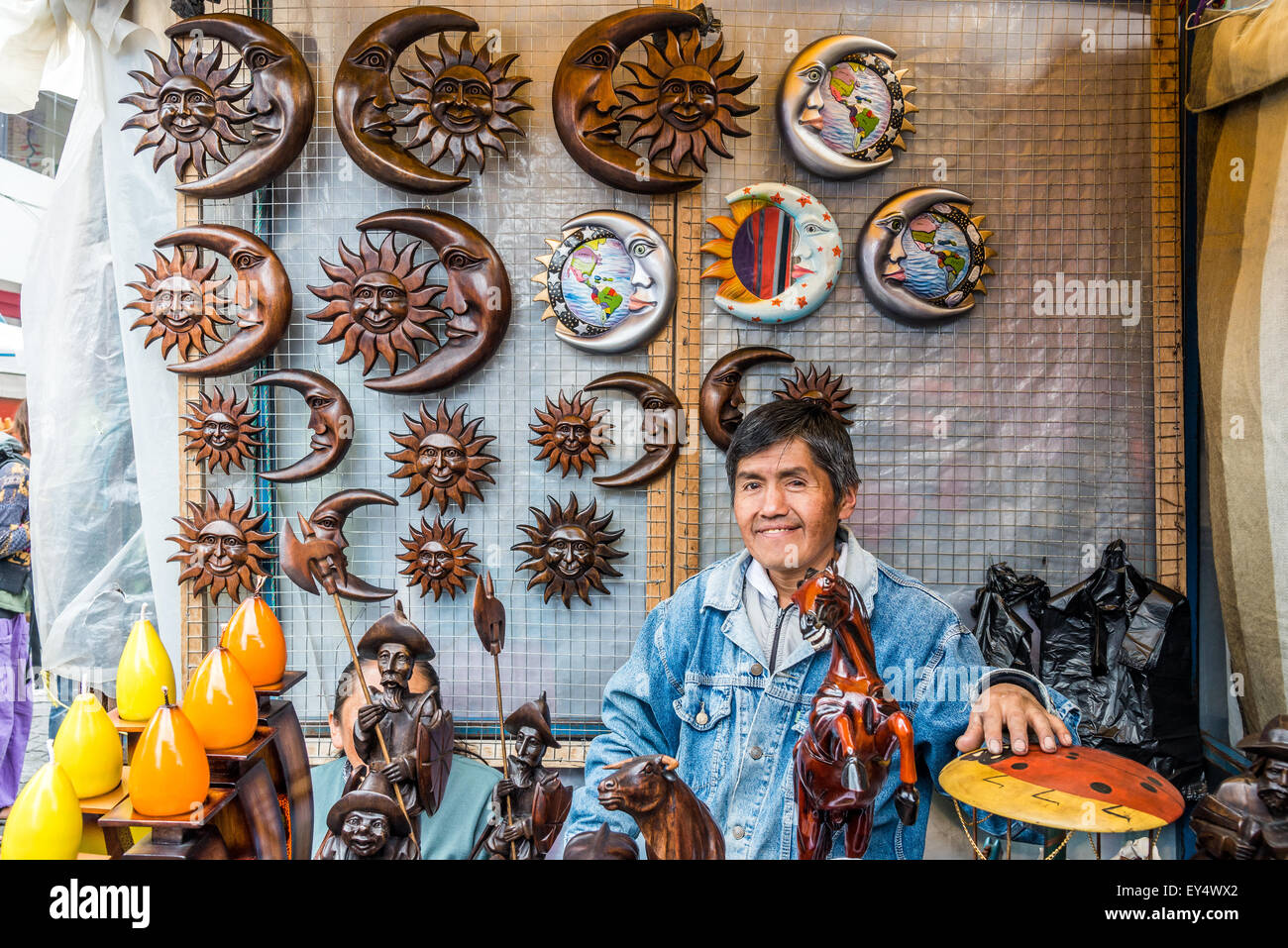 A man selling wood carved artifacts at local market. Otavalo, Ecuador ...