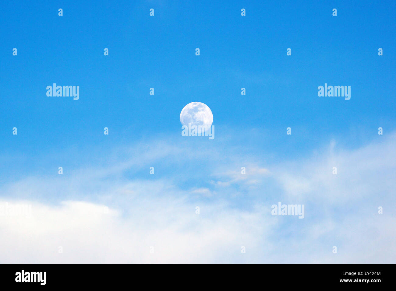 Moon rising above the clouds during a spring afternoon Stock Photo - Alamy
