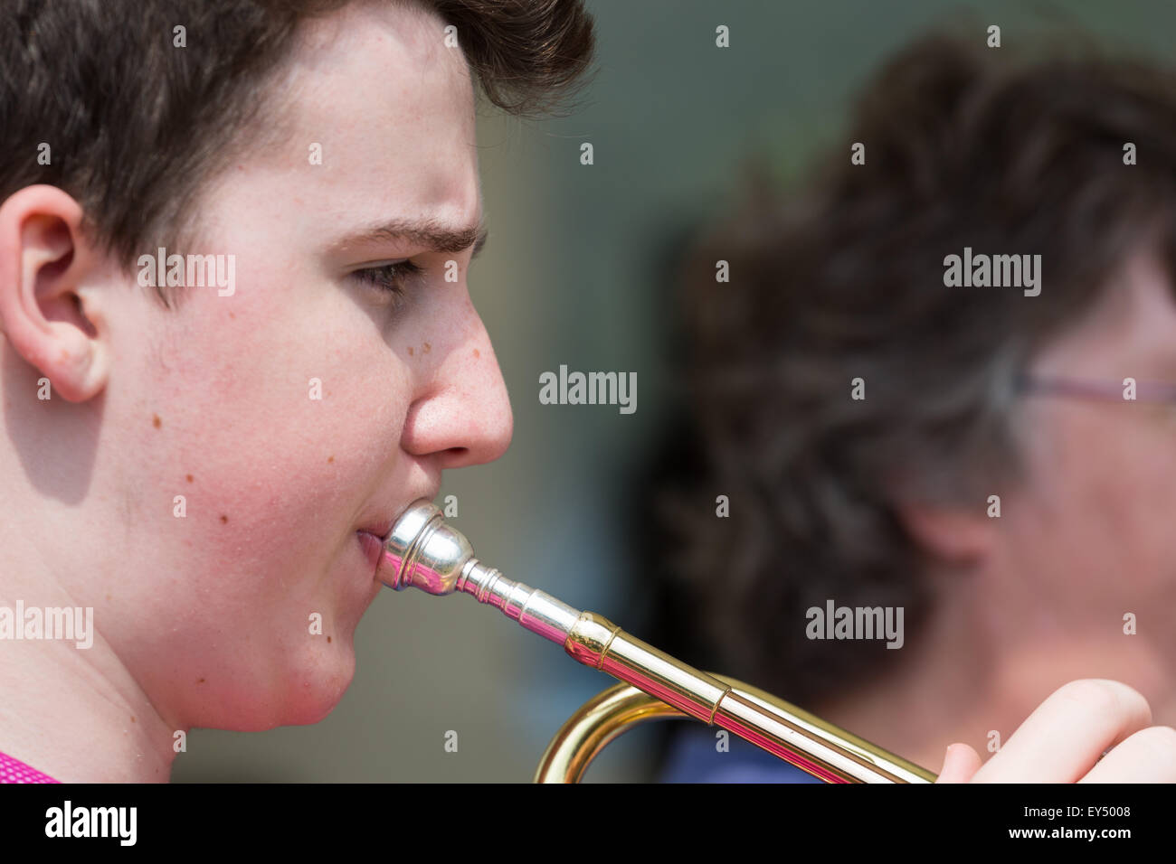 A young trumpeter playing his instrument in a a youth music group ...