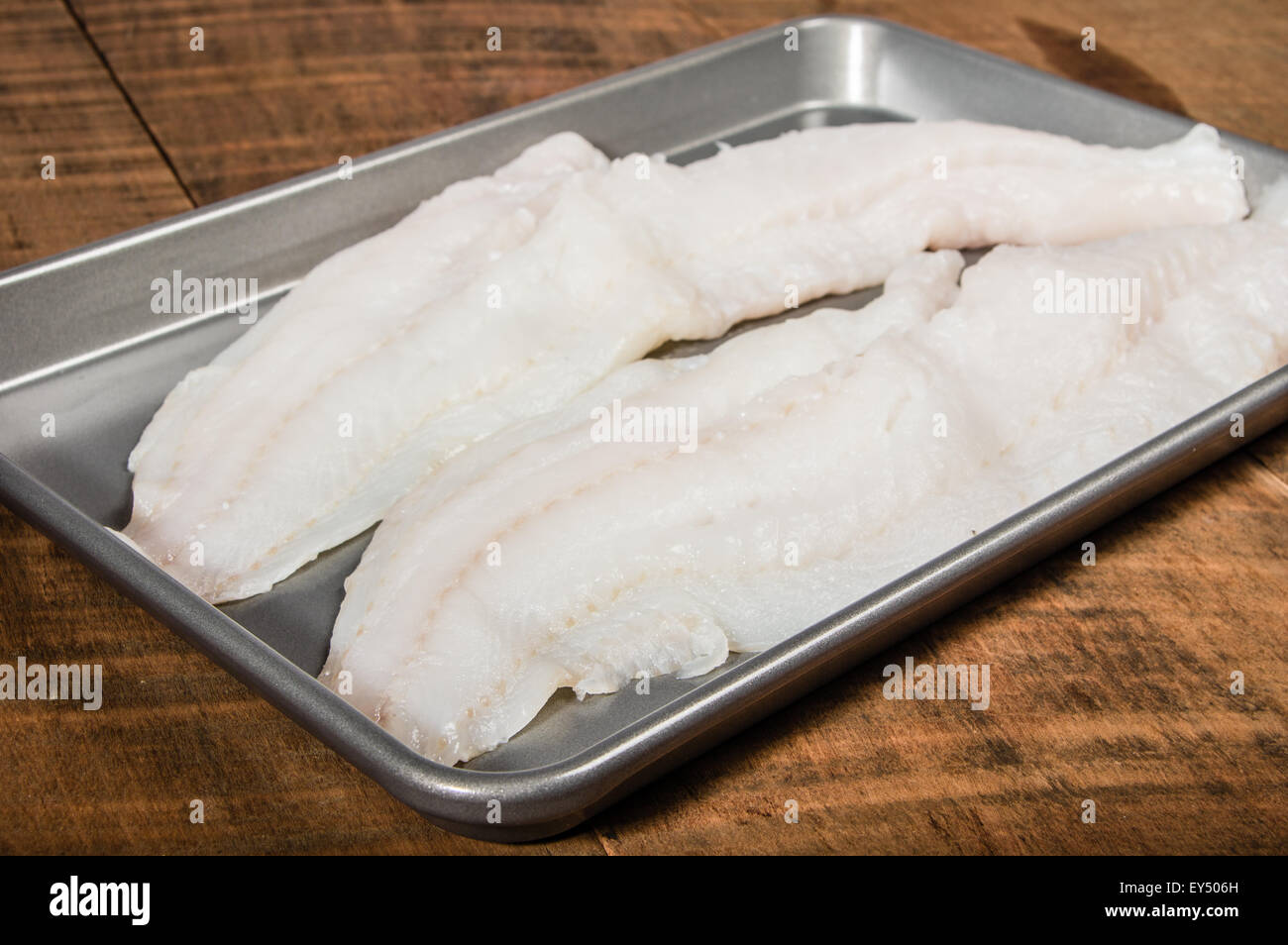 Two fillets of fresh cod fish on a baking pan Stock Photo - Alamy