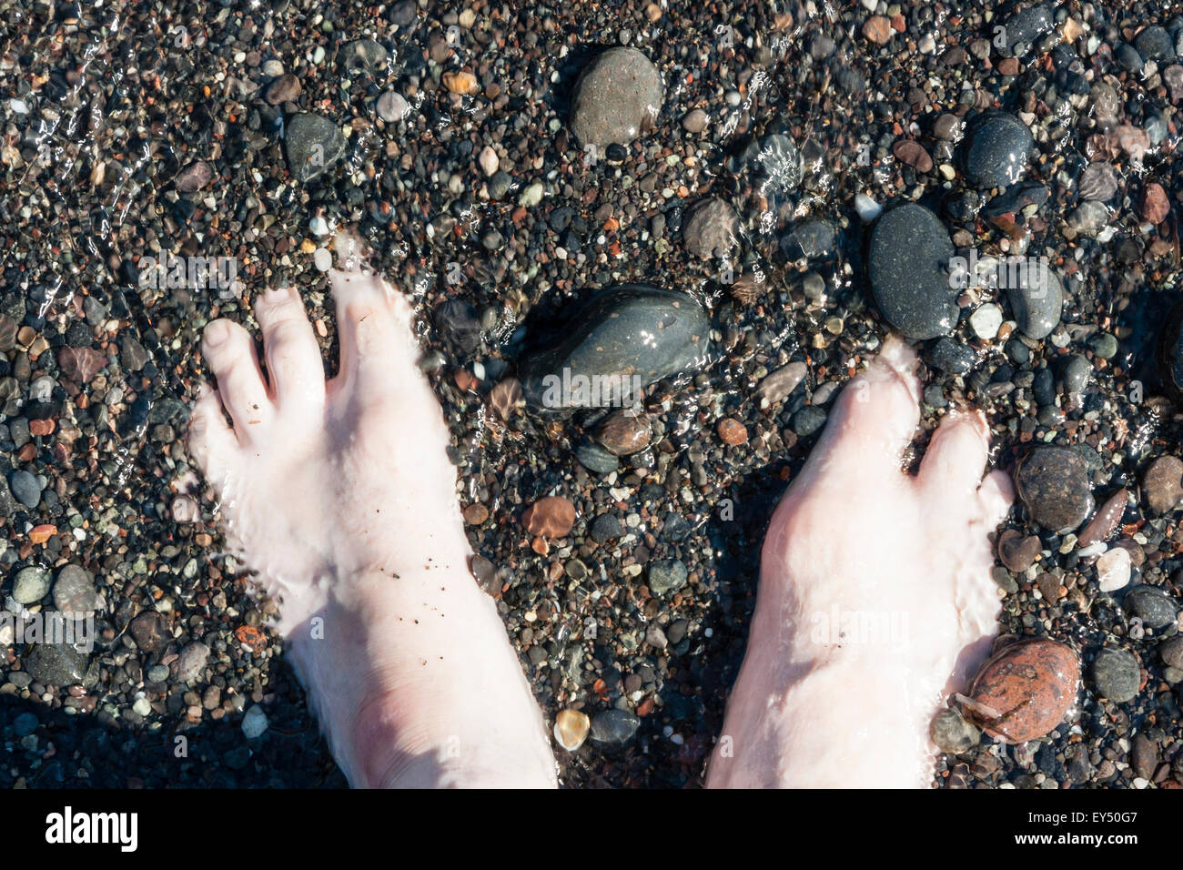 Feet on shingle beach hi-res stock photography and images - Alamy