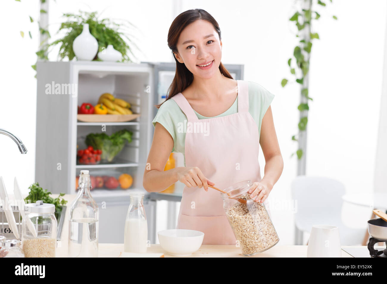 Portrait of young woman cooking in kitchen Stock Photo - Alamy