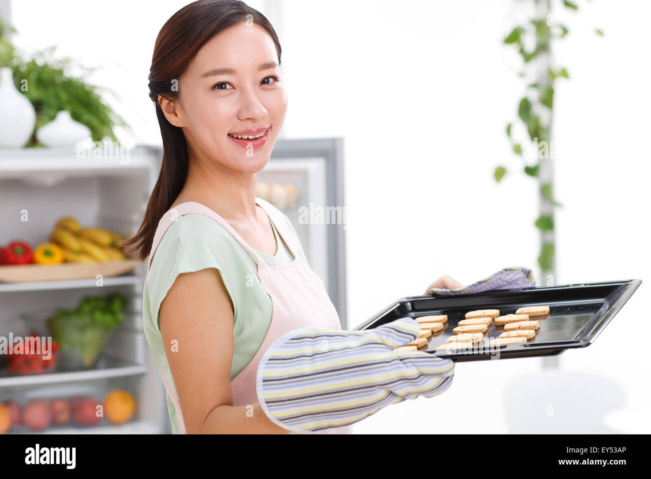 Portrait of young woman cooking in kitchen Stock Photo - Alamy