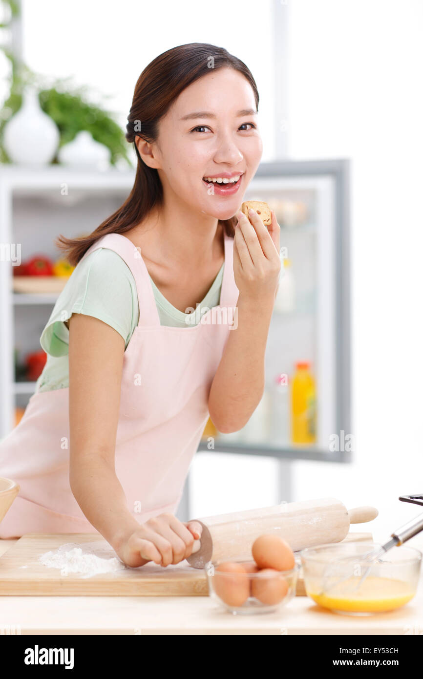 Portrait of young woman cooking in kitchen Stock Photo - Alamy