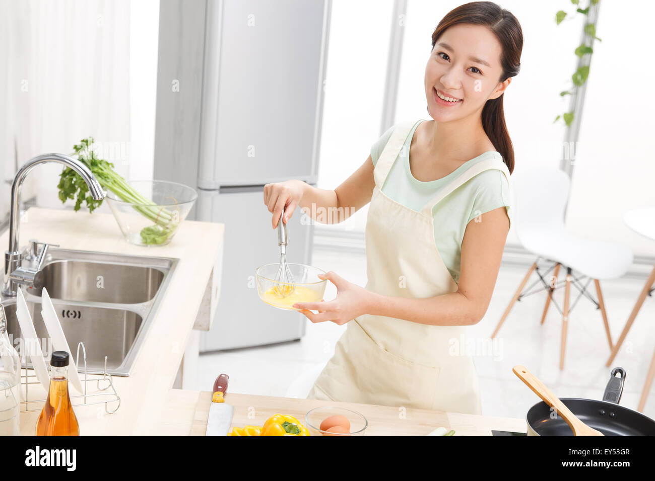 Young woman cooking in kitchen Stock Photo - Alamy