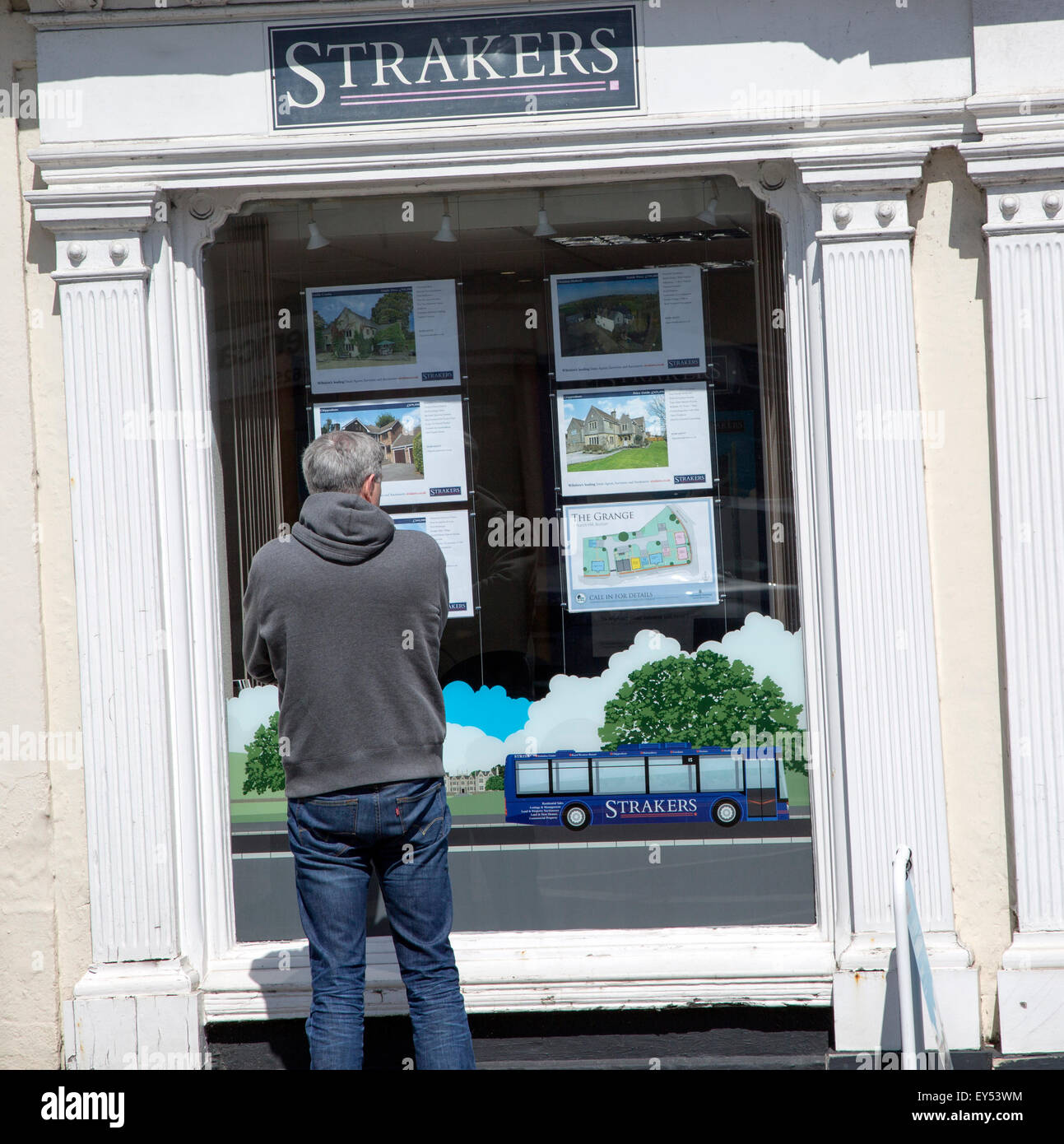Man looking in Strakers estate agent window, Chippenham, Wiltshire ...