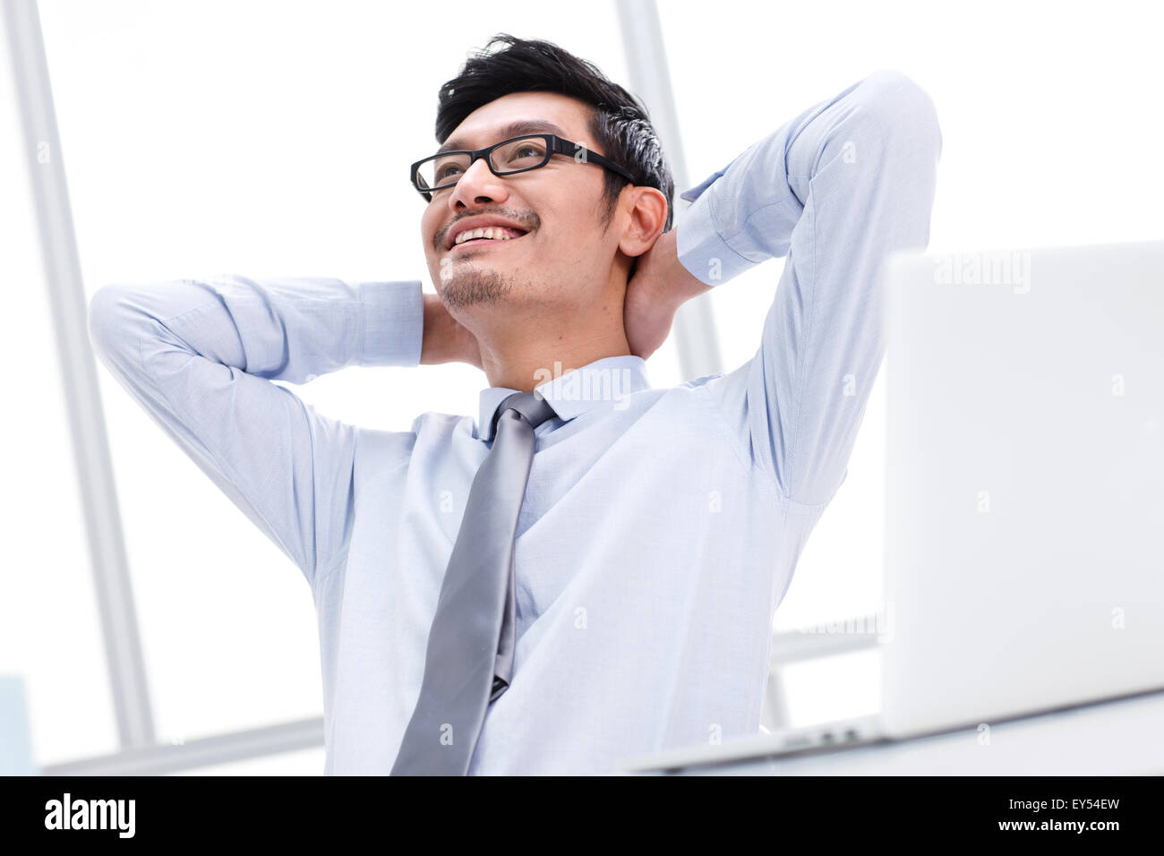 Portrait of man with hands behind head Stock Photo - Alamy