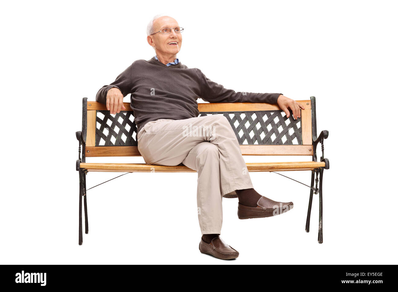 Cheerful senior sitting on a wooden bench isolated on white background ...