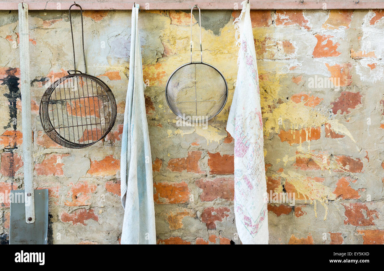 Rustic European inspired red brick wall with cooking utensils hanging ...